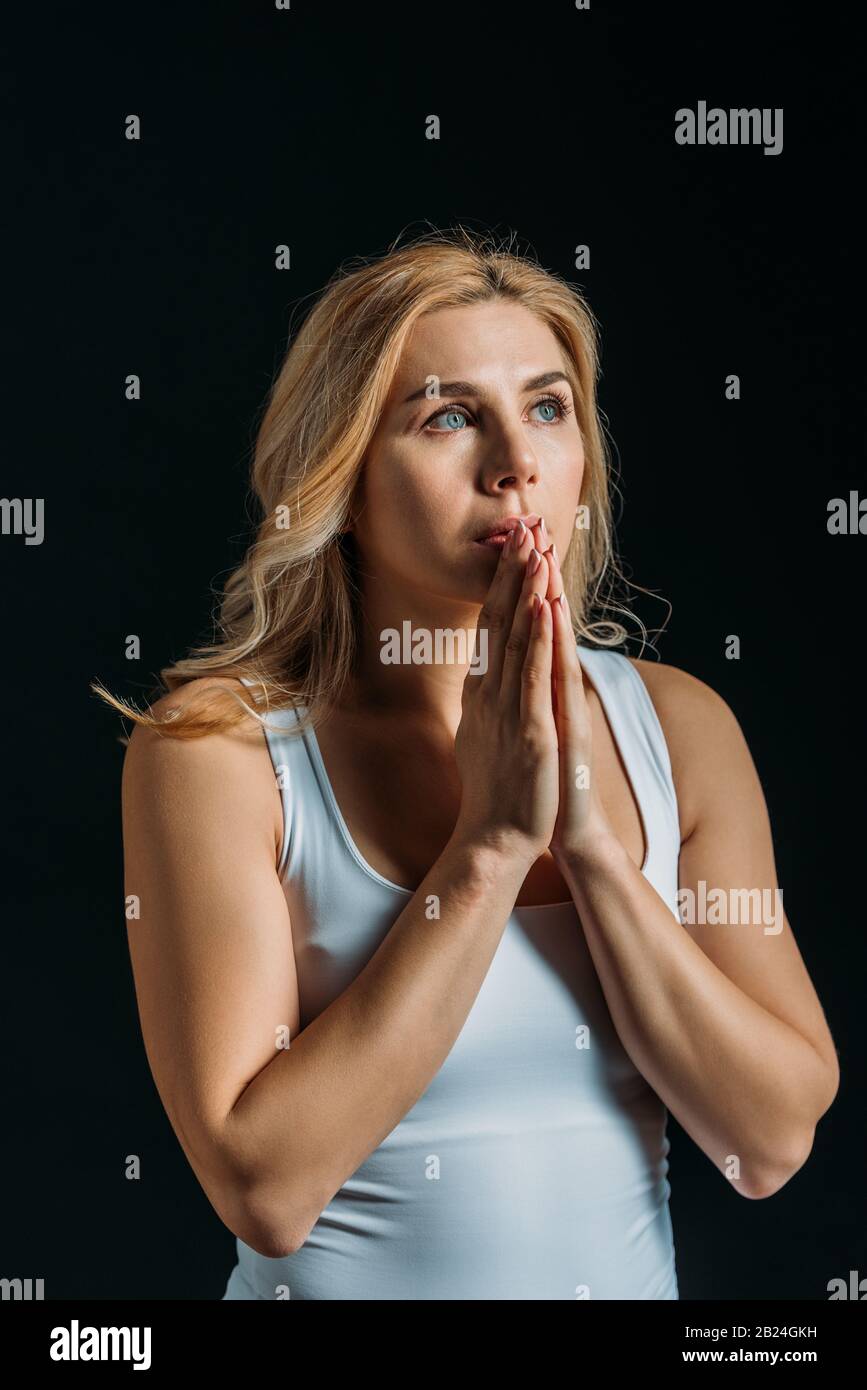Beautiful woman praying isolated on black Stock Photo - Alamy
