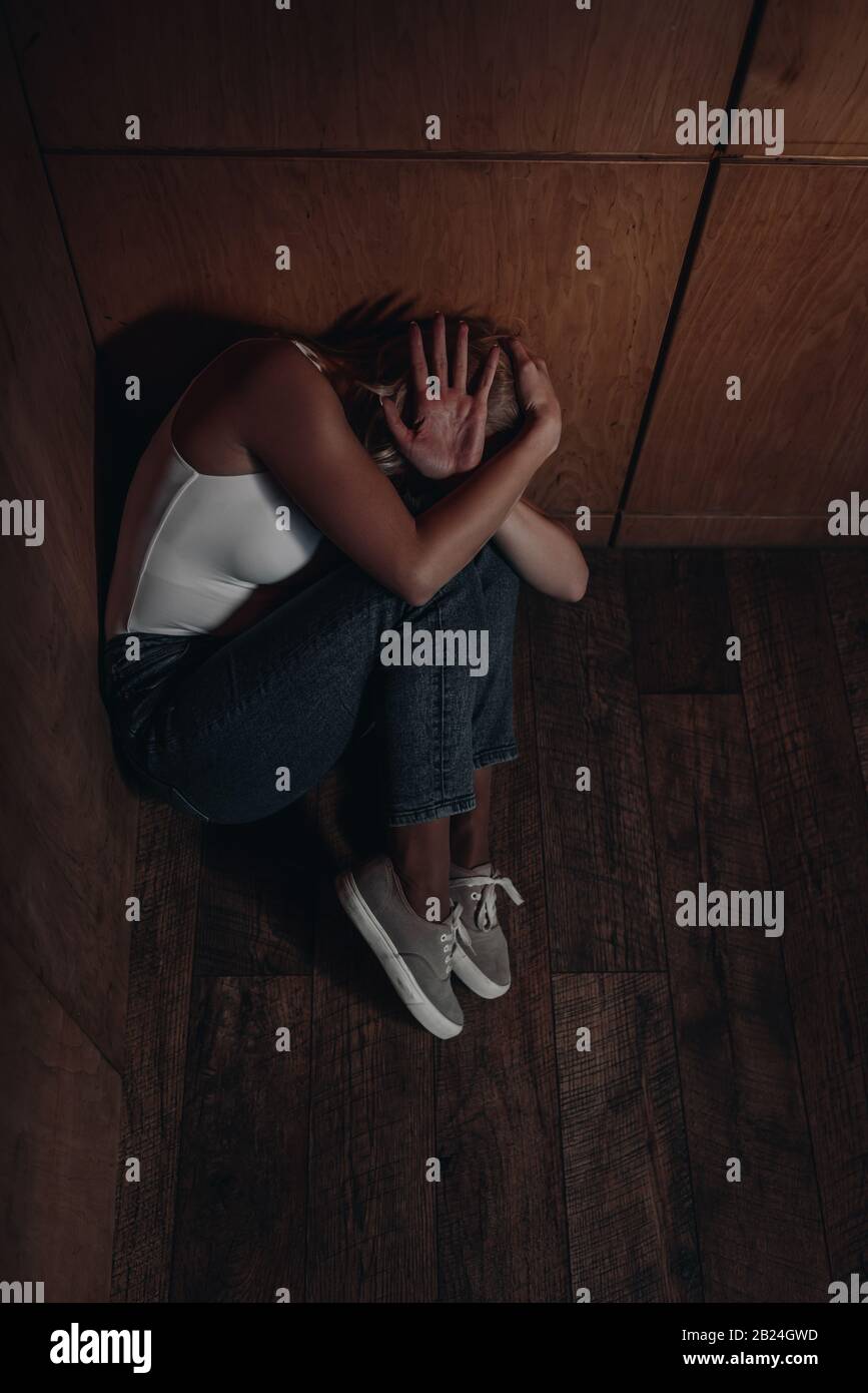 Scared victim covering head, hiding in corner Stock Photo - Alamy
