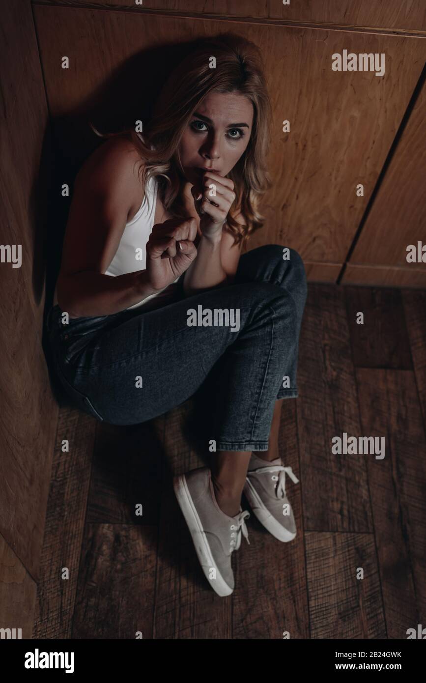 Scared victim hiding in corner Stock Photo - Alamy