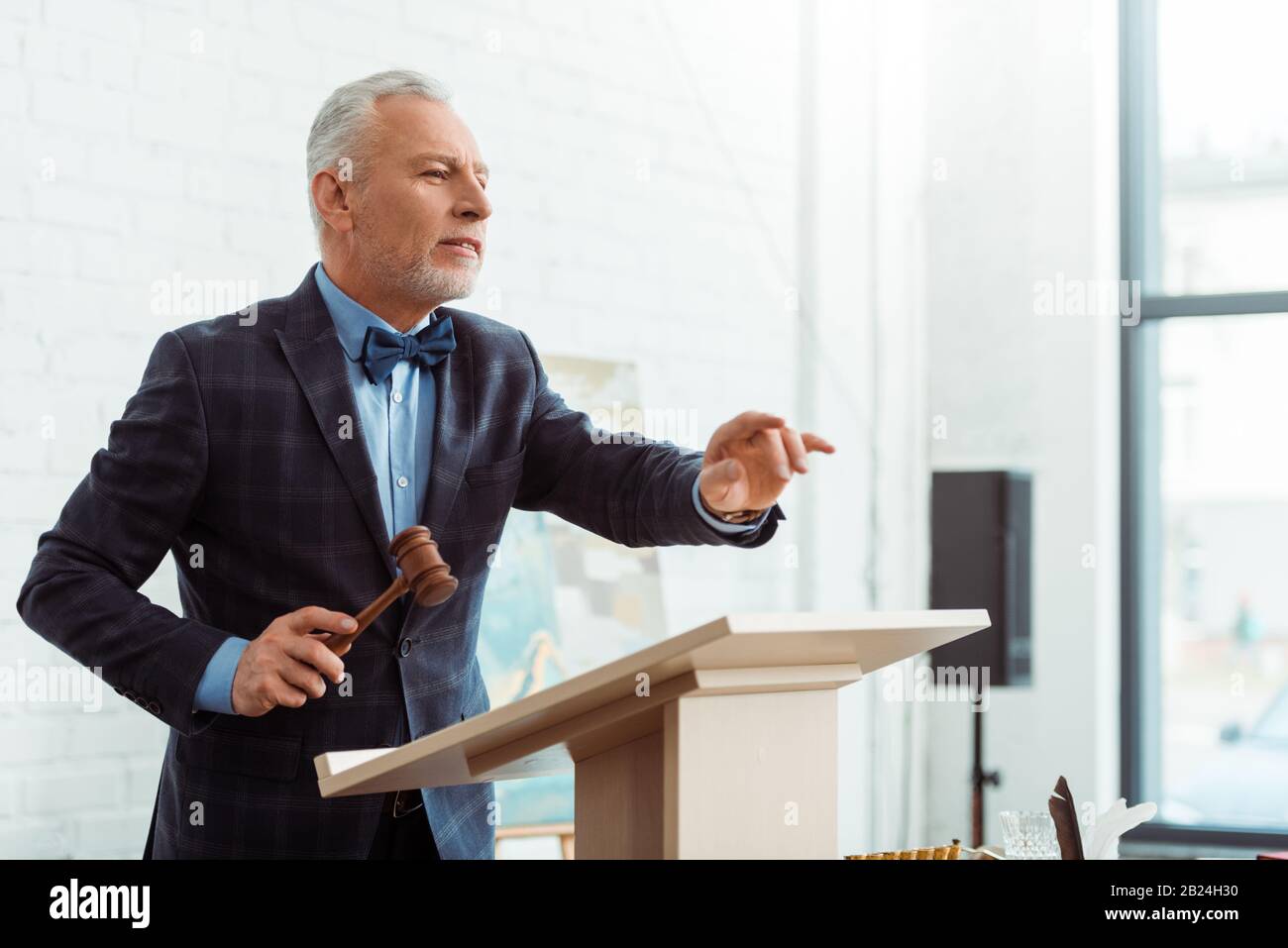auctioneer holding gavel and pointing with finger during auction Stock ...