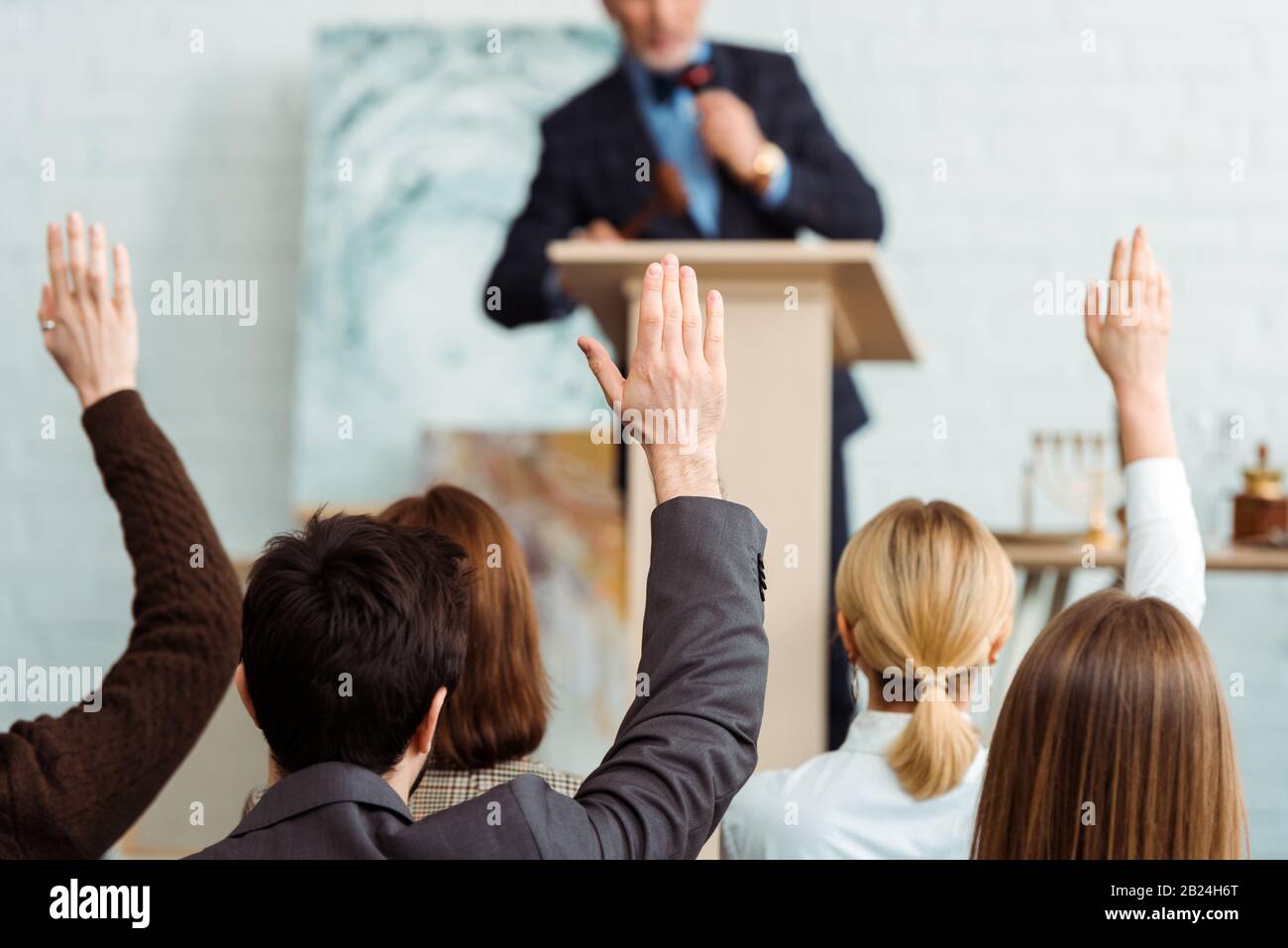 back view of buyers raising hands to auctioneer during auction Stock ...