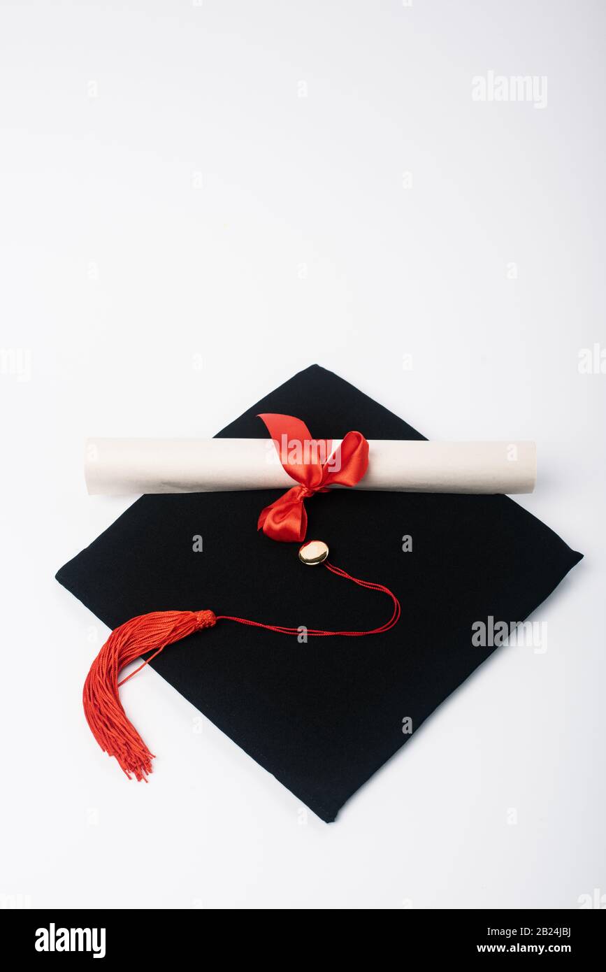 Diploma with nice bow on black graduation cap on white background Stock ...
