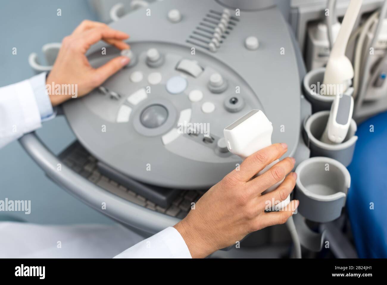 partial view of professional female doctor working with ultrasound ...