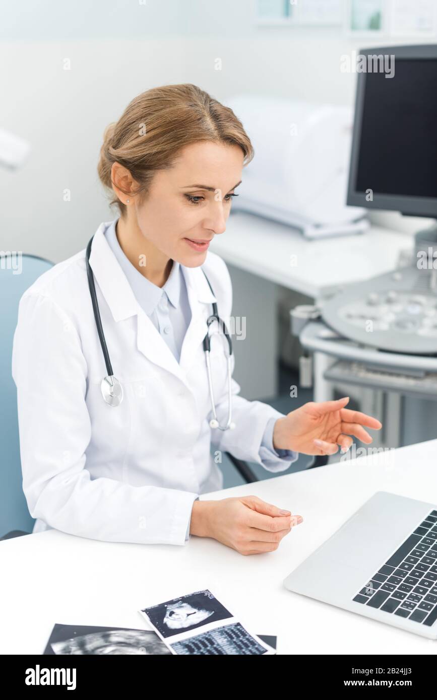 professional female doctor working on laptop in clinic with ultrasound ...