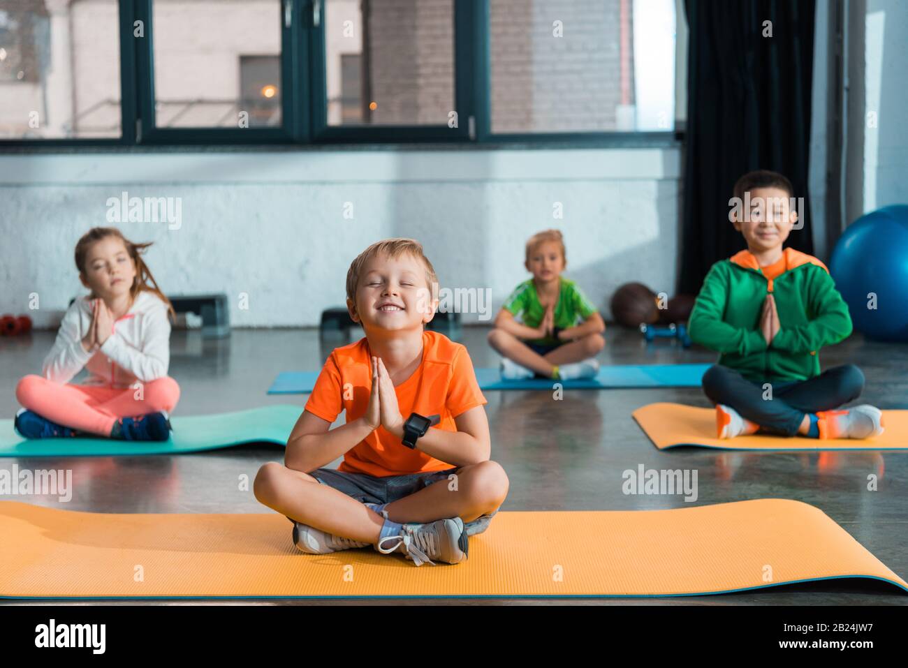 Selective focus of multiethnic children with clenched hands and crossed ...