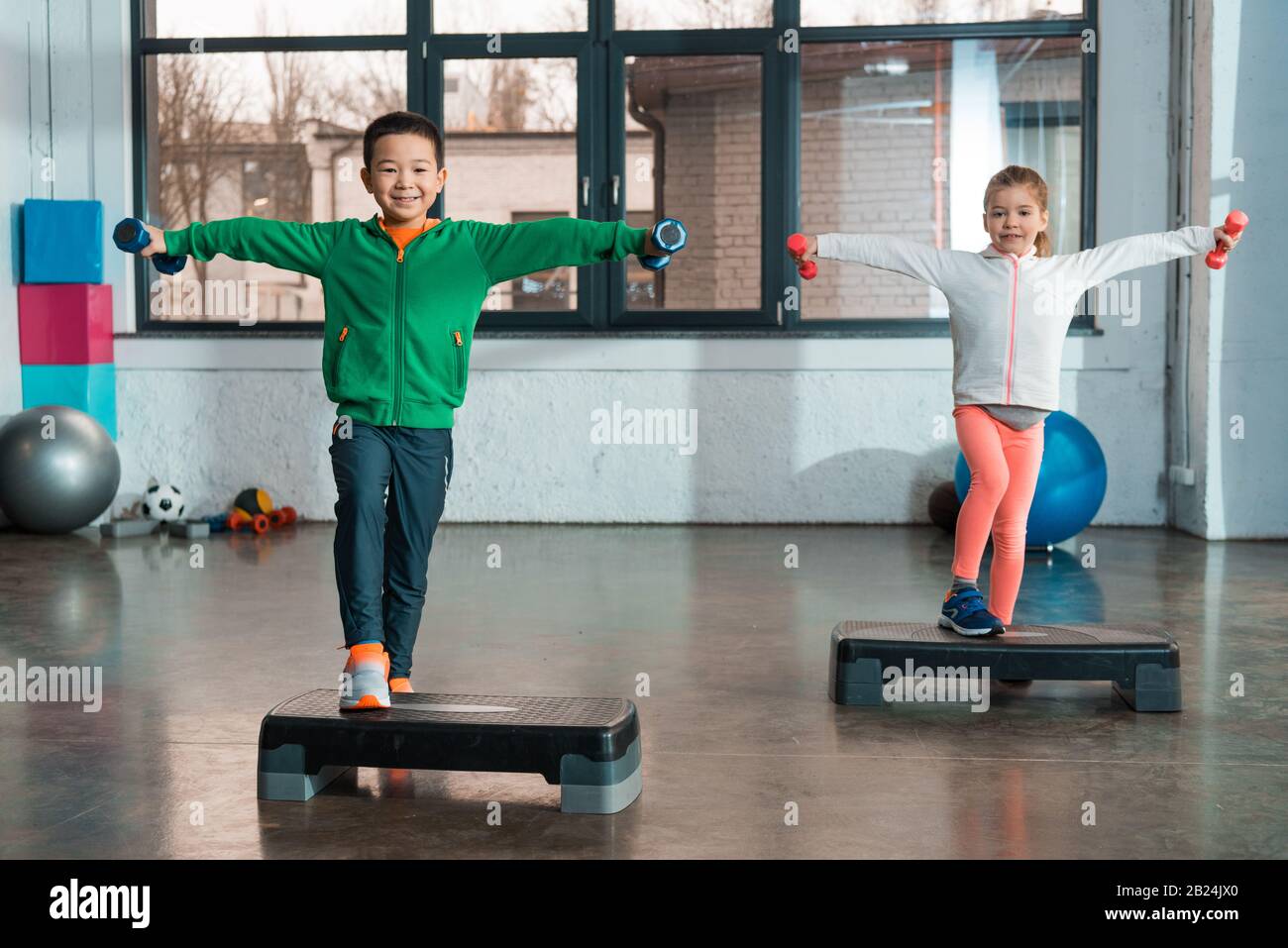 Multicultural children with outstretched hands holding dumbbells and ...