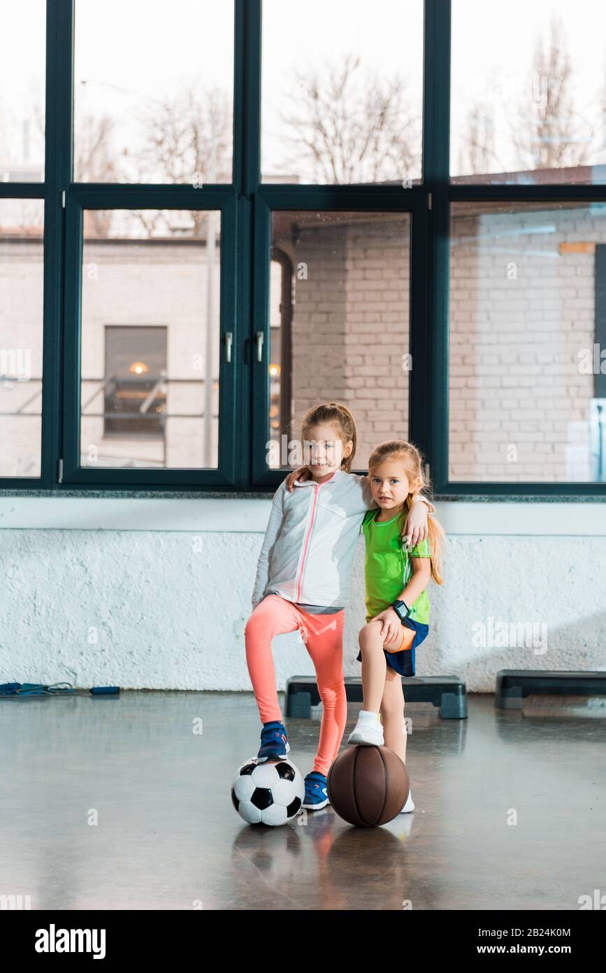 Children hugging and putting legs on balls in gym Stock Photo - Alamy