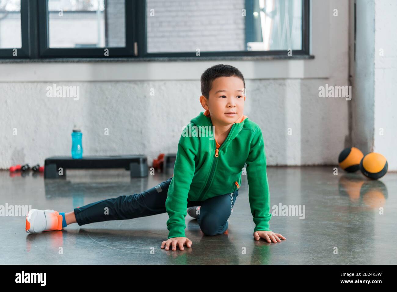 Selective focus of boy stretching in gym Stock Photo - Alamy