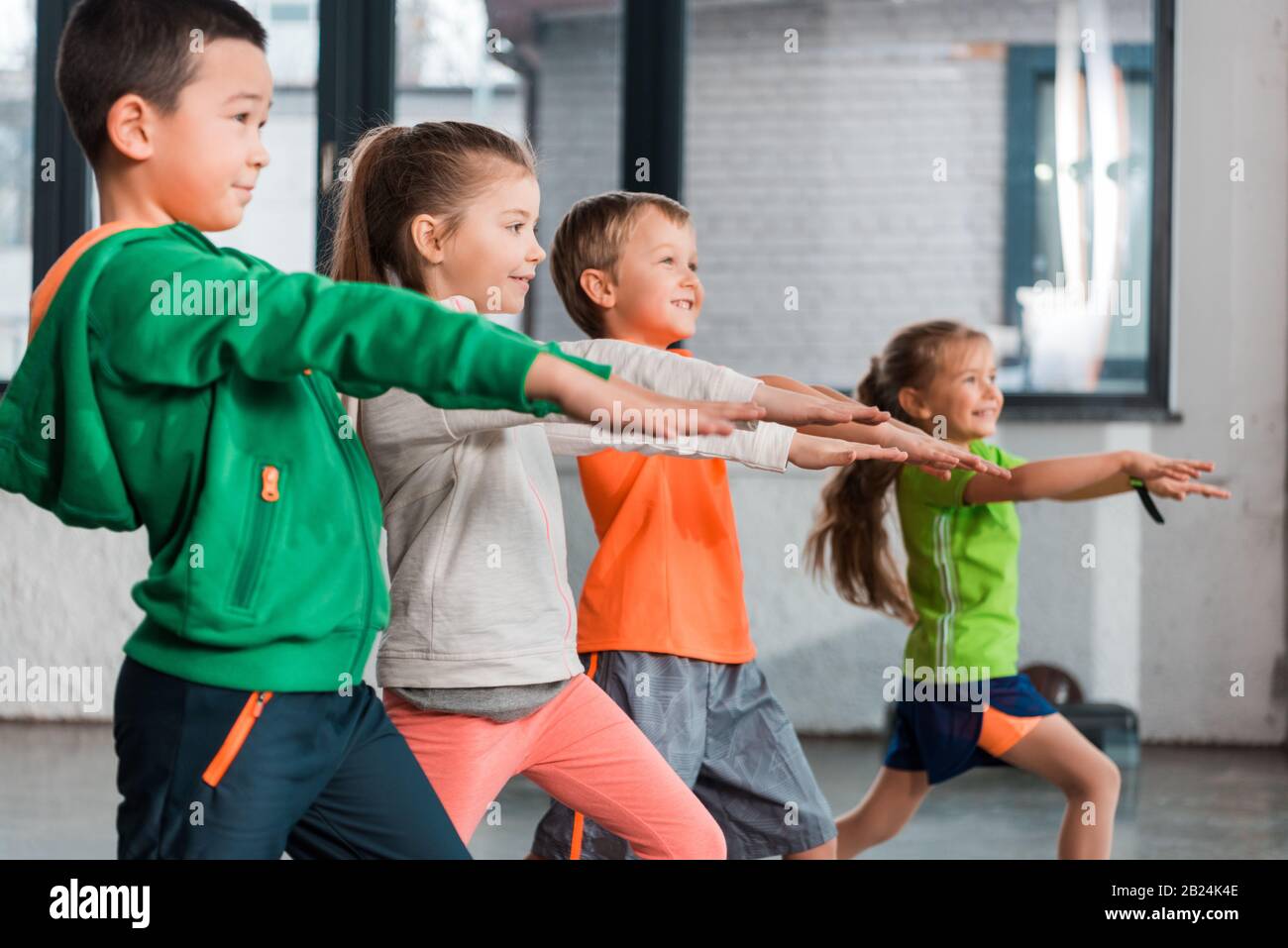 Selective focus of multiethnic children with outstretched hands doing ...