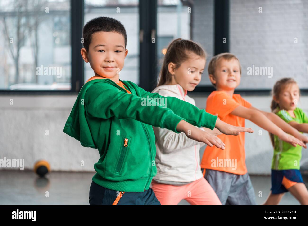Selective focus of multicultural children with outstretched hands doing ...