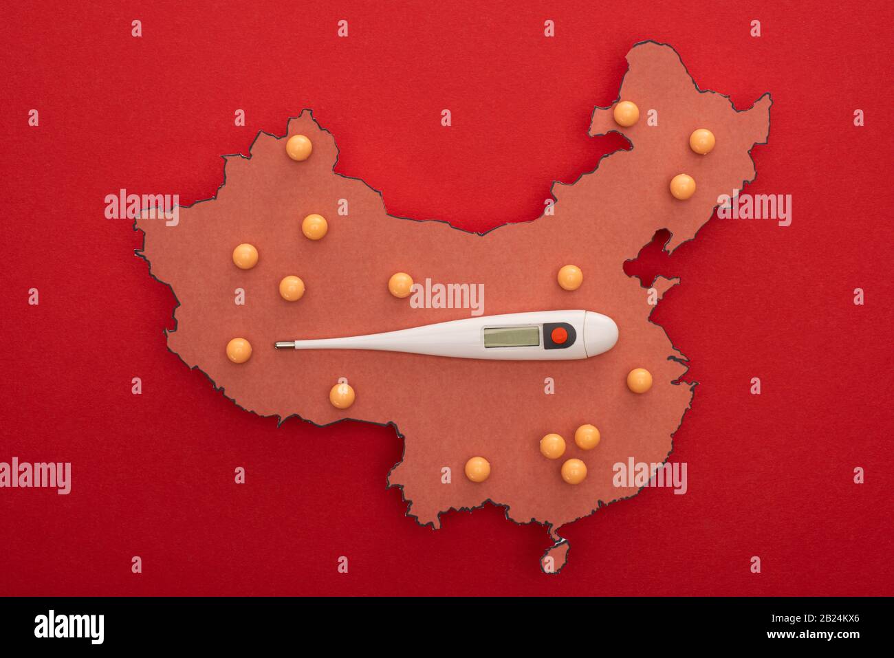 Top view of thermometer on map of china with push pins on red ...