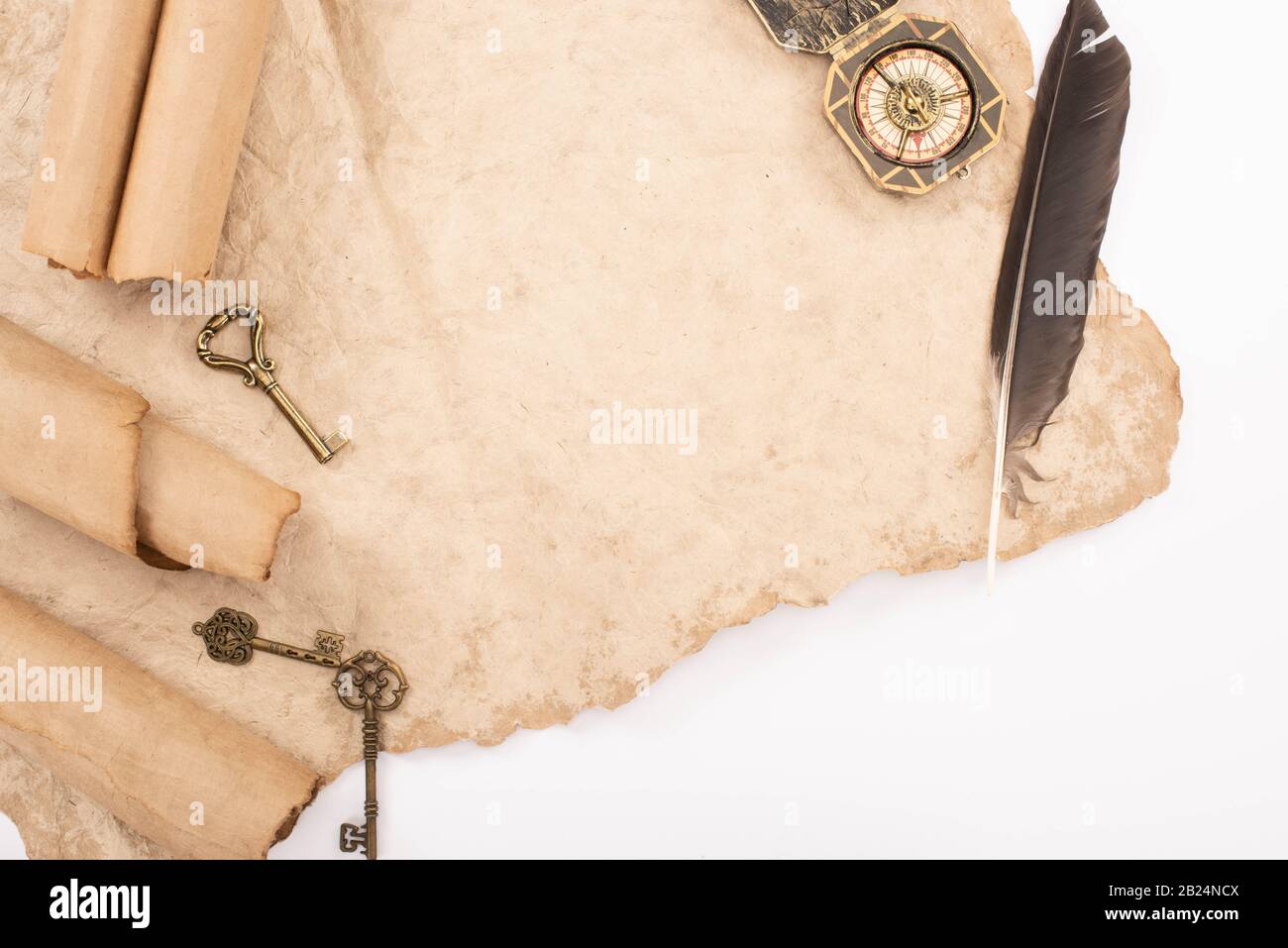 top view of vintage keys and compass on aged paper isolated on white ...