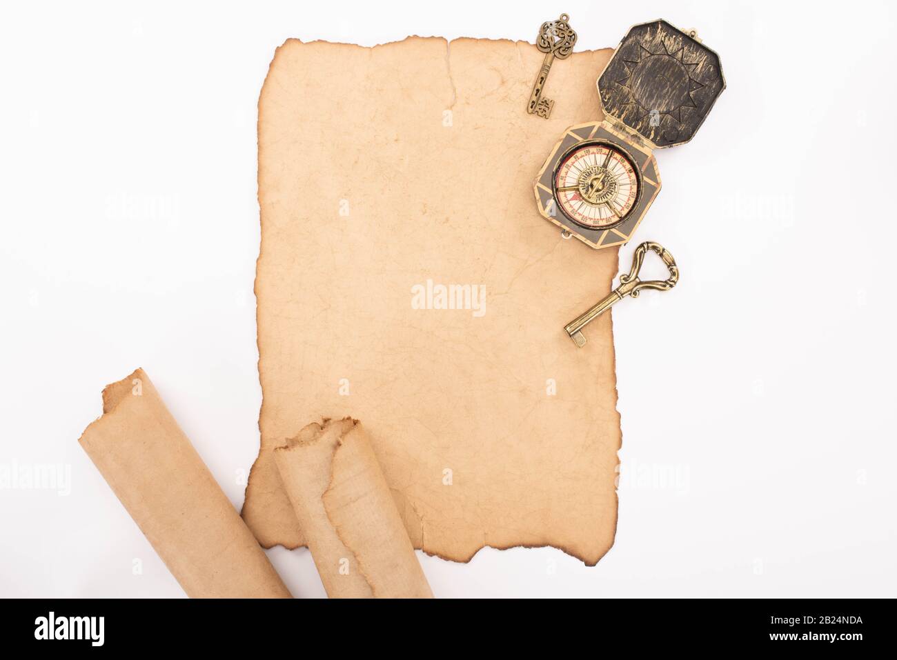 top view of vintage compass, keys and aged parchment paper isolated on ...