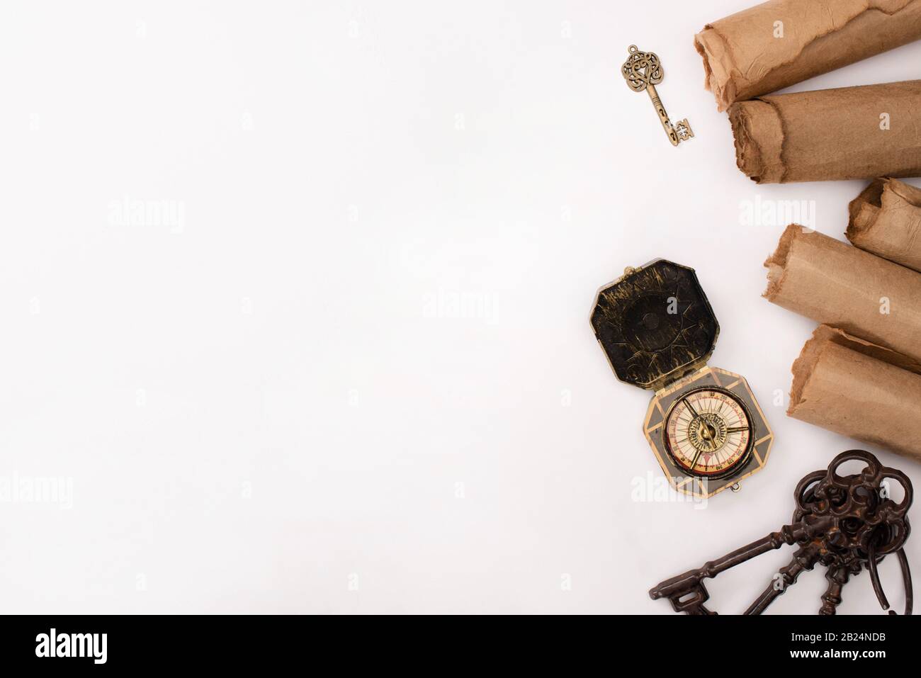top view of vintage compass, keys and aged parchment paper isolated on ...