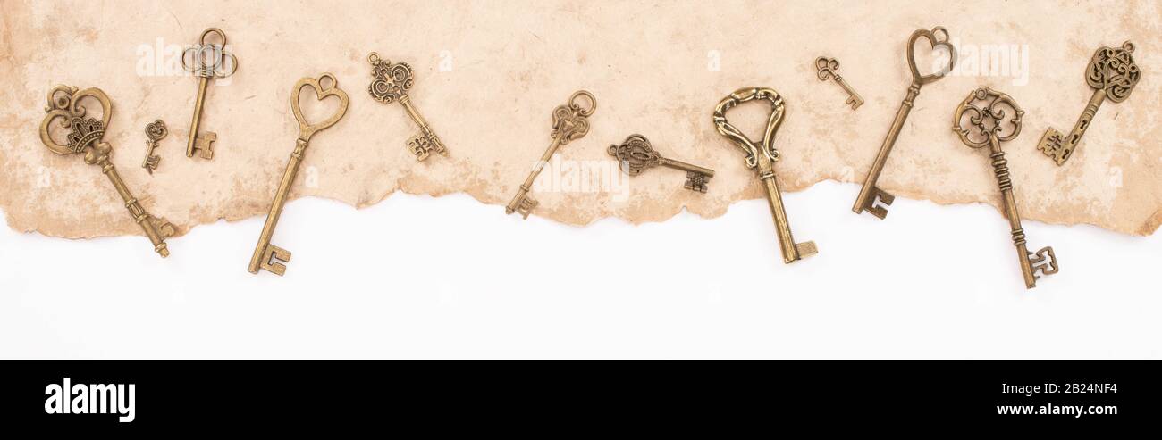 top view of vintage keys on aged paper isolated on white, panoramic ...