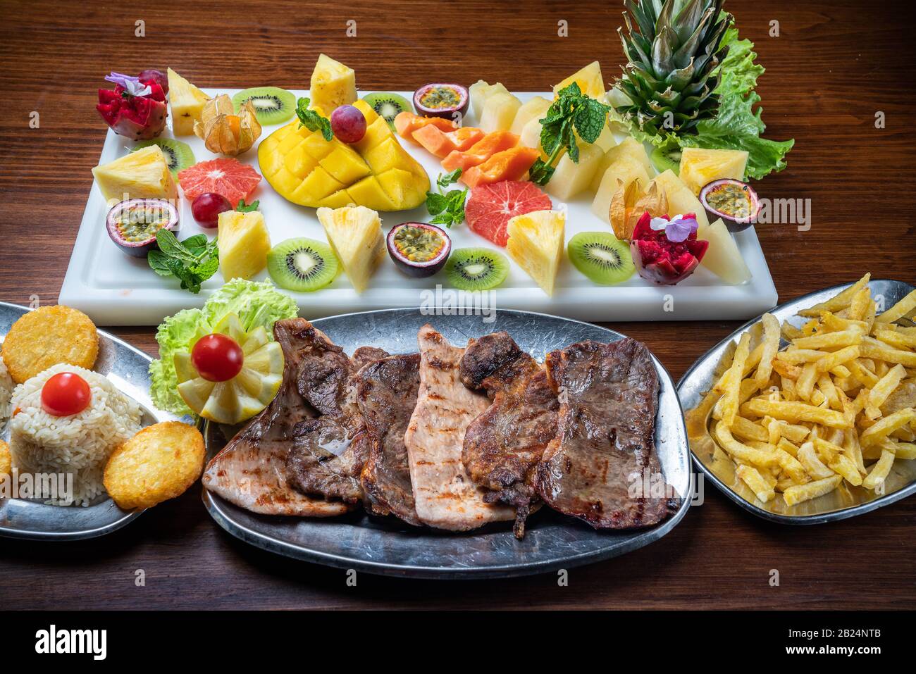 Grilled meat, side dish and dessert in a restaurant Stock Photo - Alamy