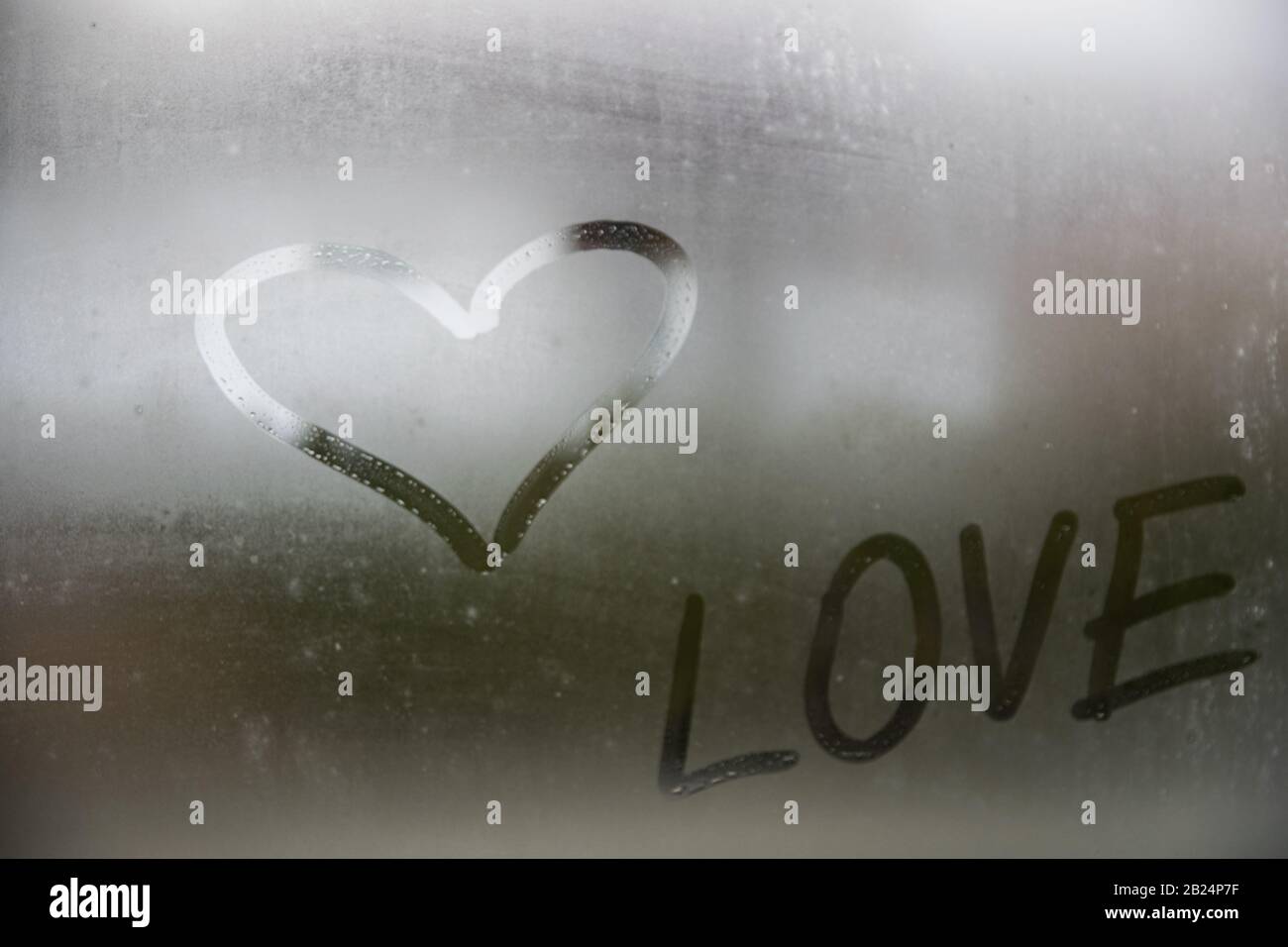Beautiful heart symbol and love word on the glass window with water ...