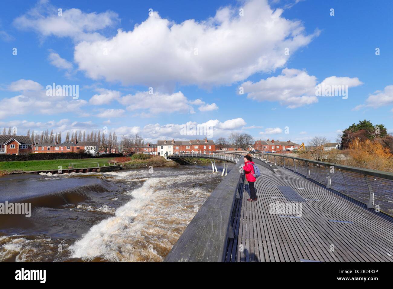 A pedestrian looking at the high water levels in the River Aire after ...