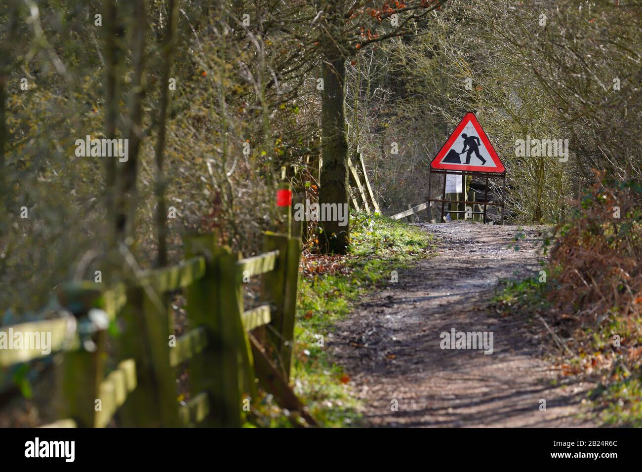 A road works sign is placed on a country footpath, to warn pedestrians ...