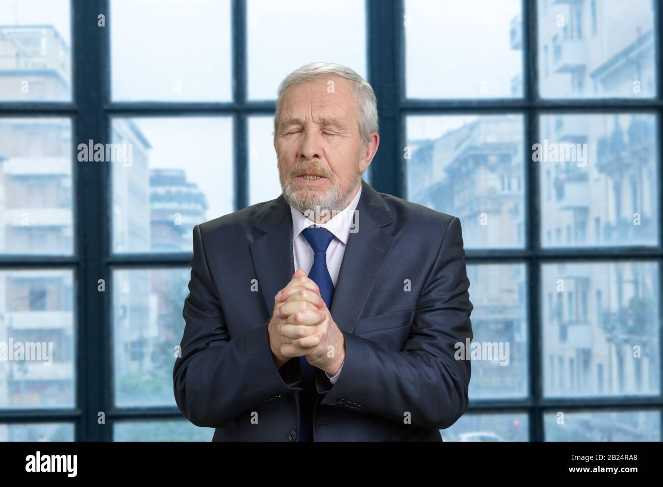 Old businessman praying to god Stock Photo - Alamy