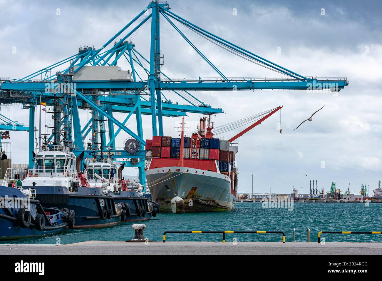 Tugboats and container ship moored at the dock Stock Photo - Alamy