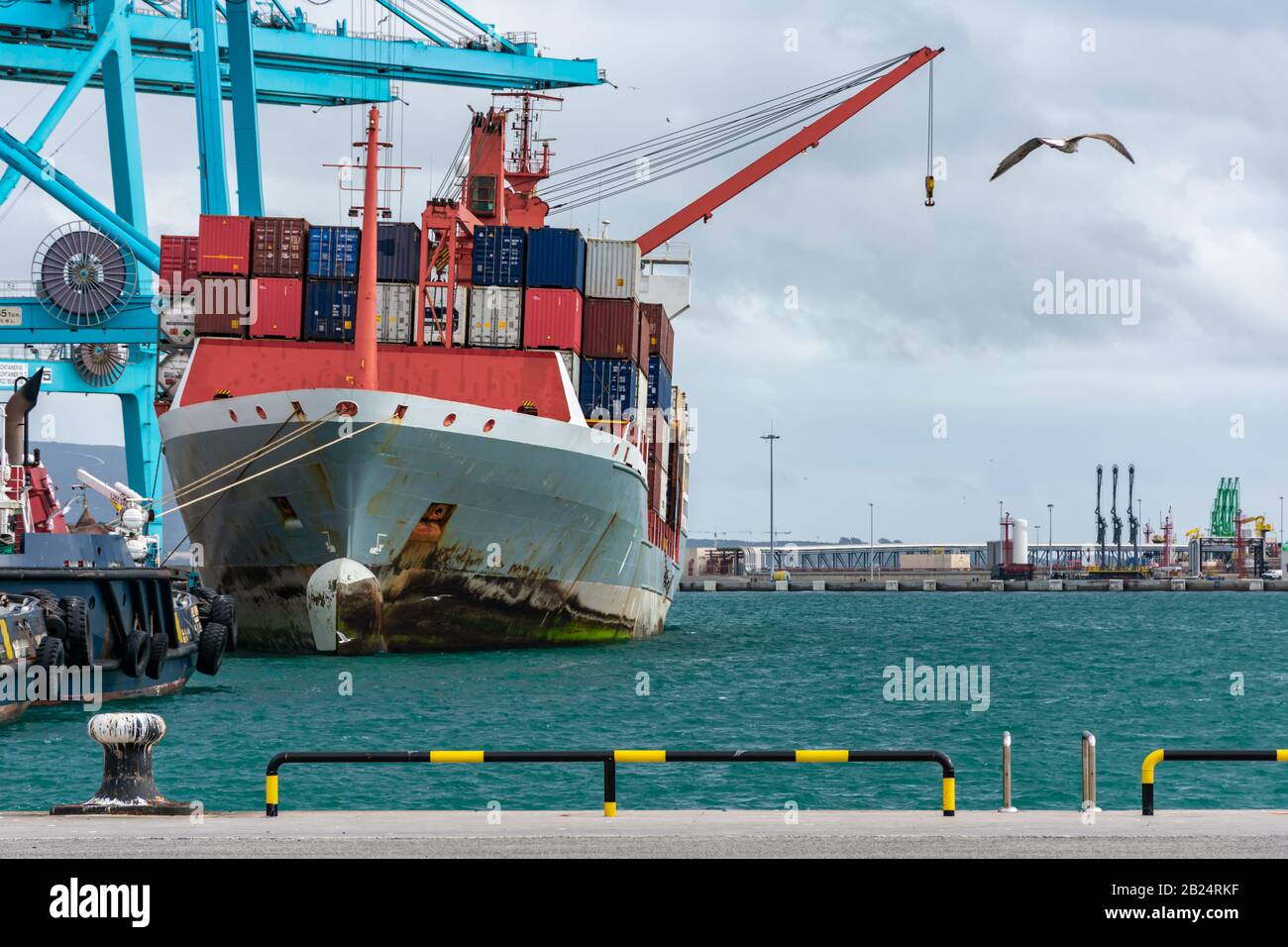 Tugboats and container ship moored at the dock Stock Photo - Alamy
