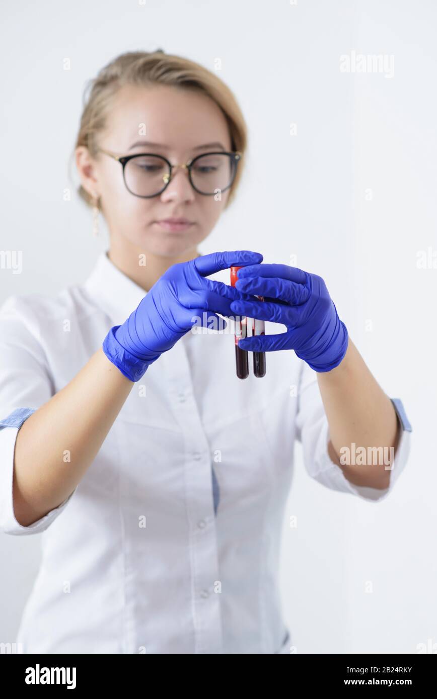 Doctor examining two tubes with blood samples in his hands. Hands ...
