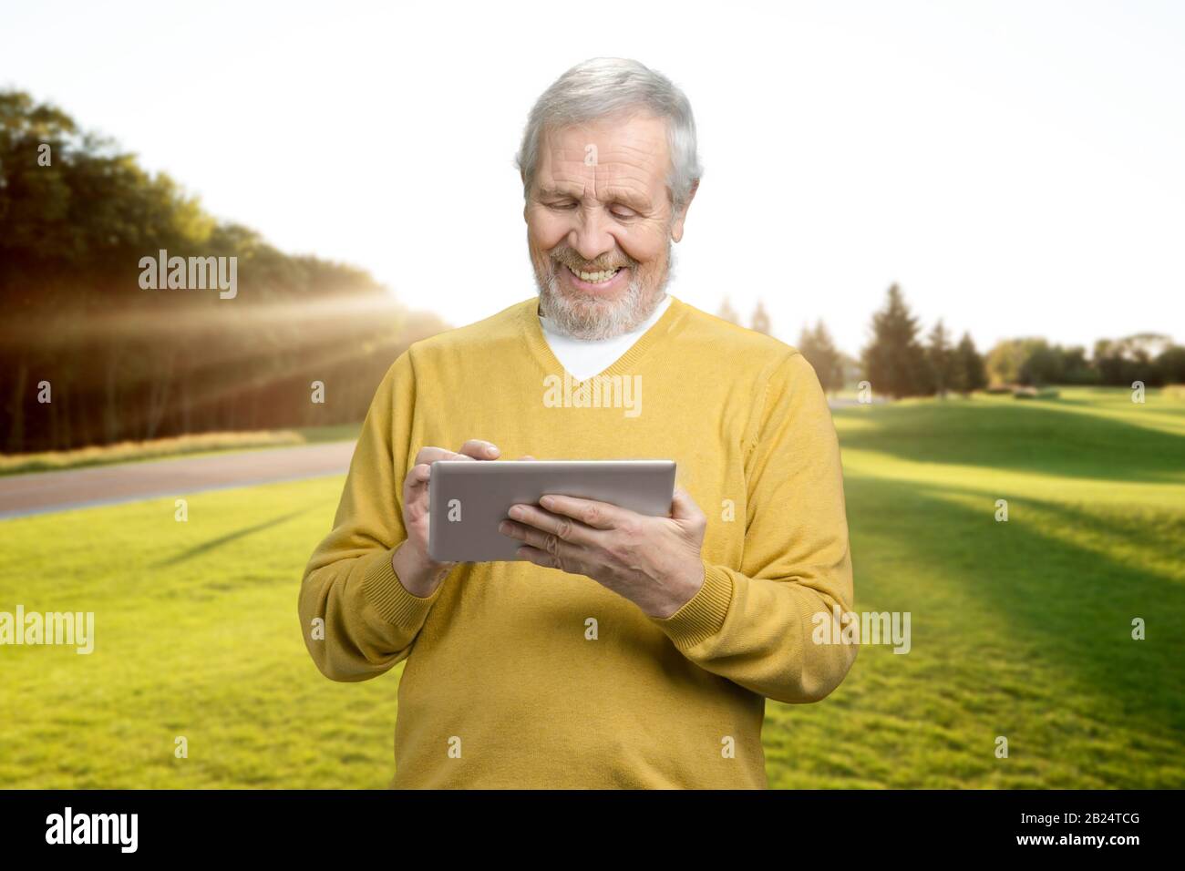 Happy old man with tablet outdoor Stock Photo - Alamy