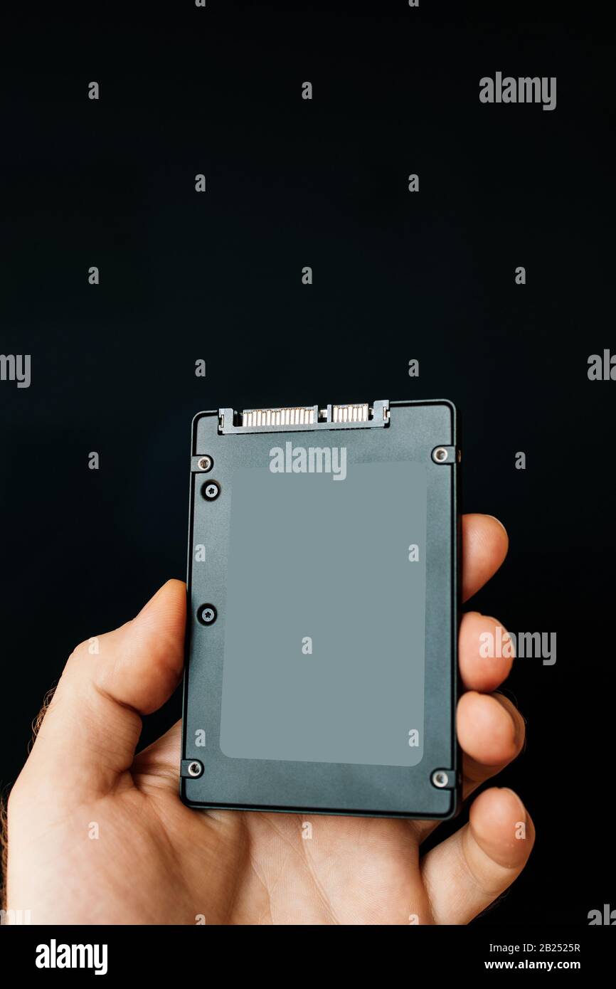 Man hand holding against black background new powerful SSD Solid State ...