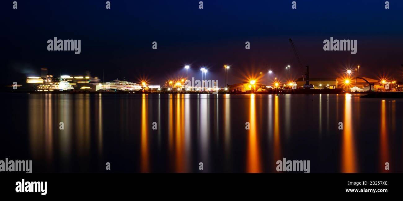 The lights of the shipyards, ferry terminal and docks are rflected in ...