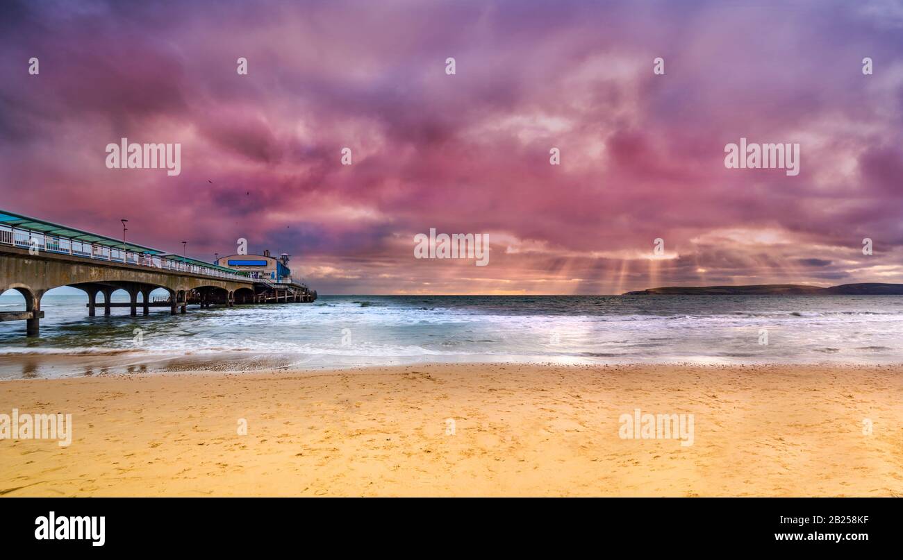Colourful skies over Bournemouth Pier are reflected in the water Stock ...