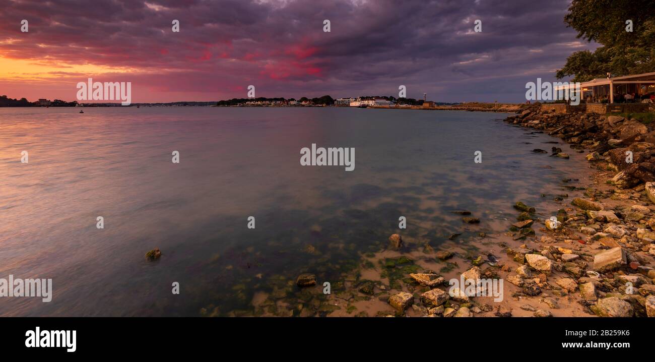 Crimson sunset over Bramble Bay towards Sandbanks in Dorset with ...