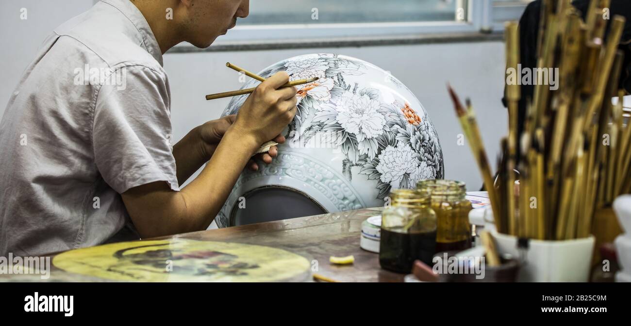 BEIJING, СHINA - JUNE 03: Chinese craftsman paints a large porcelain ...
