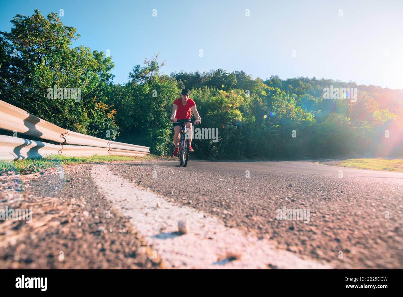 Fit male biker cyclist riding his bike cycle on an asphalt road at ...
