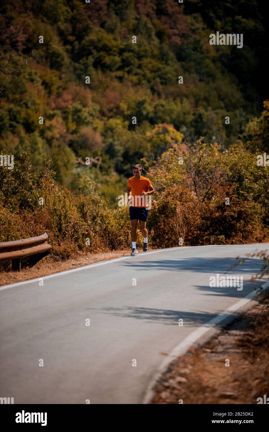Jogging male fitness model working out training for marathon on forest ...
