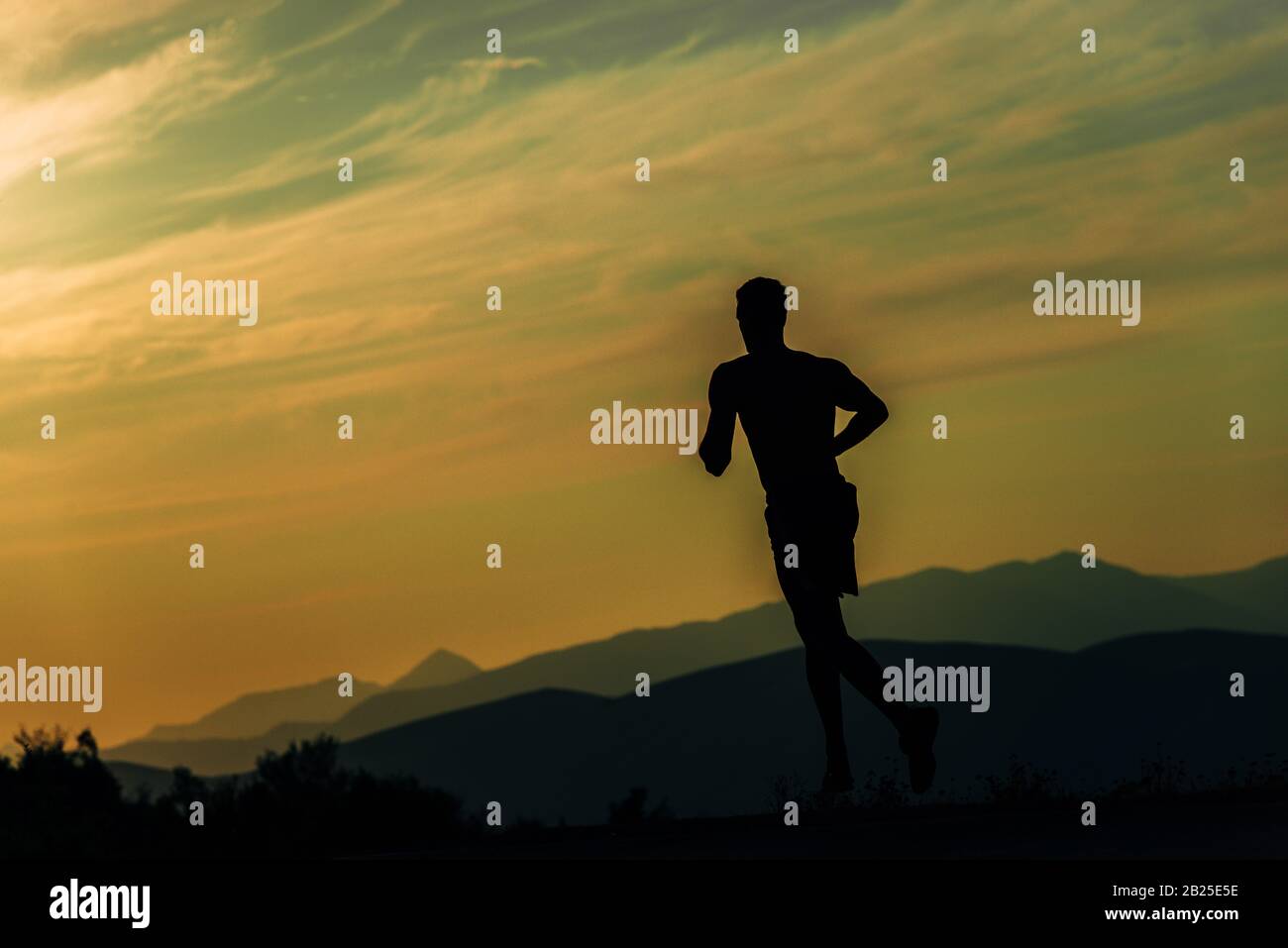 Trail running silhouette man on mountain path exercising Stock Photo ...