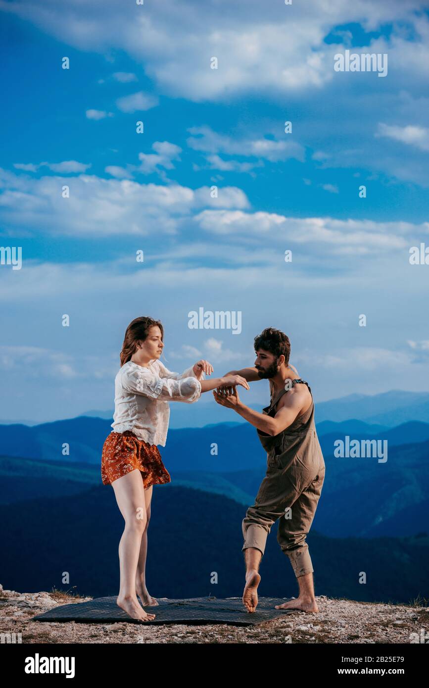 Romantic young loving couple dancing outdoors under blue sky at ...