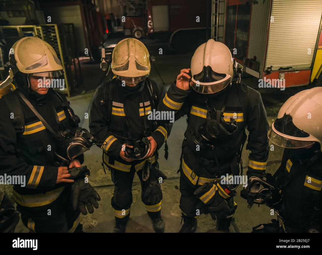 Group of firefighters with uniform inside the fire station preparing ...