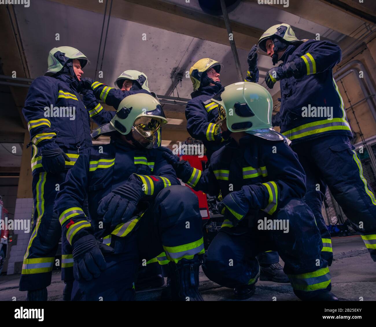 Portrait of group firefighters in front of firetruck inside the fire ...
