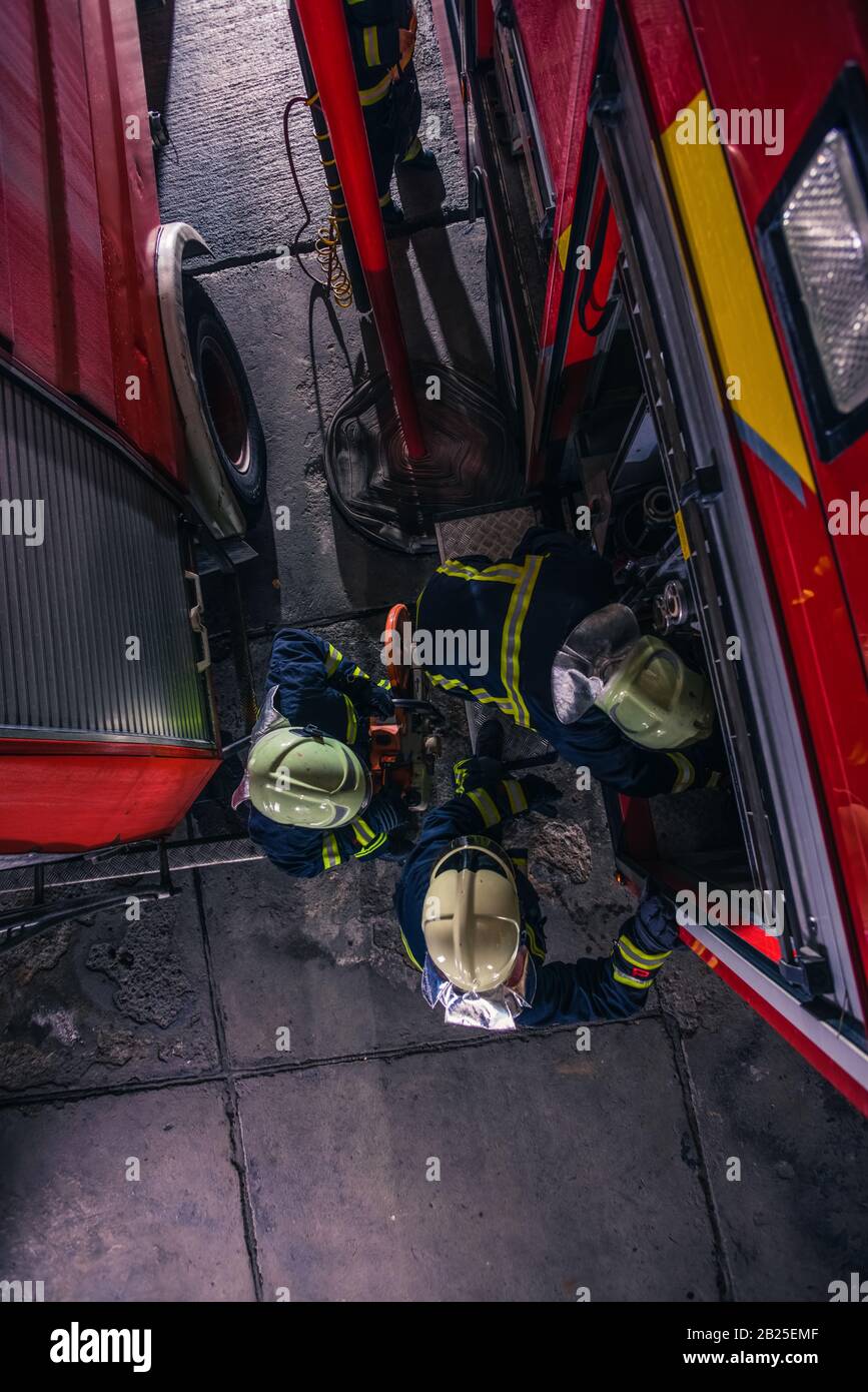 Firemen checking the fire engine inside the fire department from a bird ...