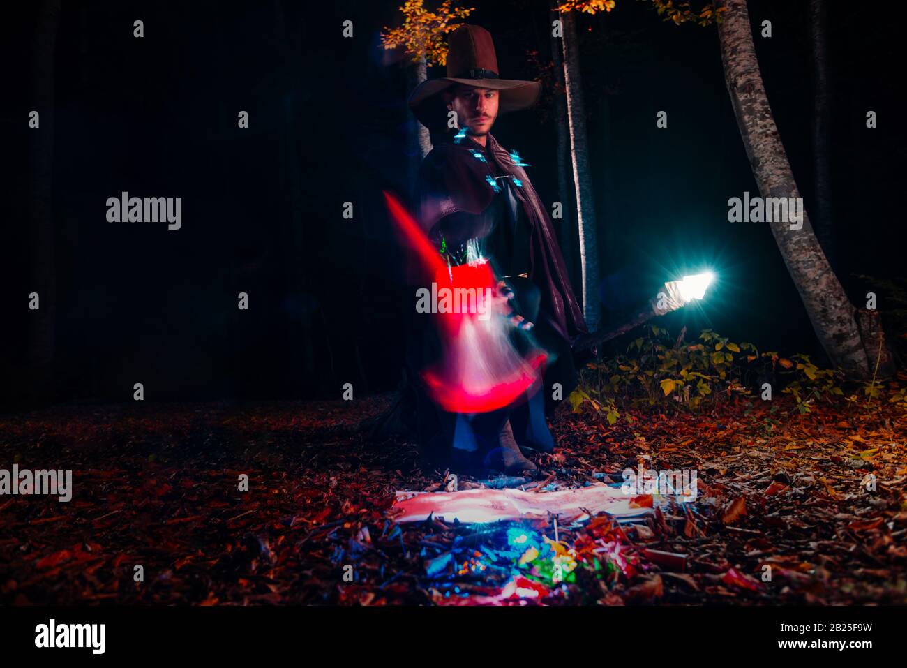 Wizard (mage) casting a spell with his magical staff while standing in ...