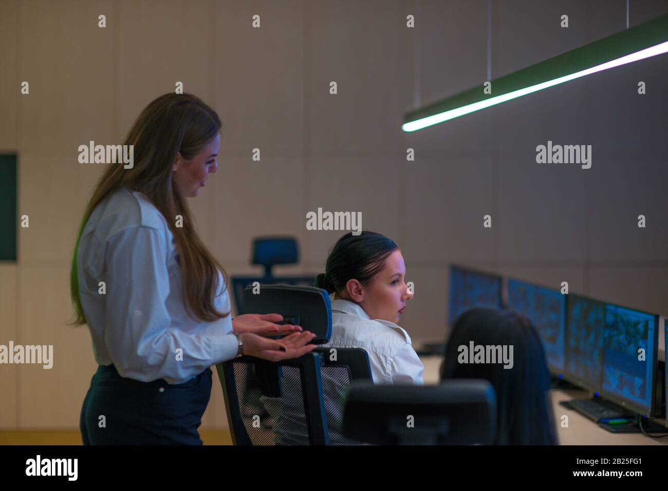 Security guard monitoring modern CCTV cameras in a surveillance room ...