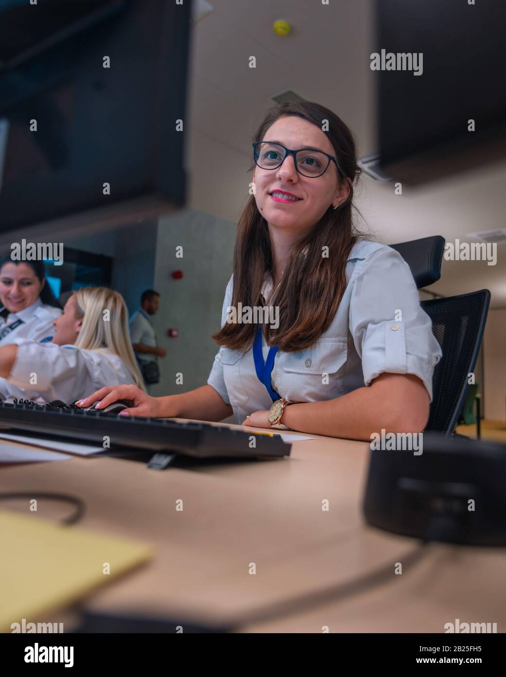 Female security guards working on computers while sitting in the main ...