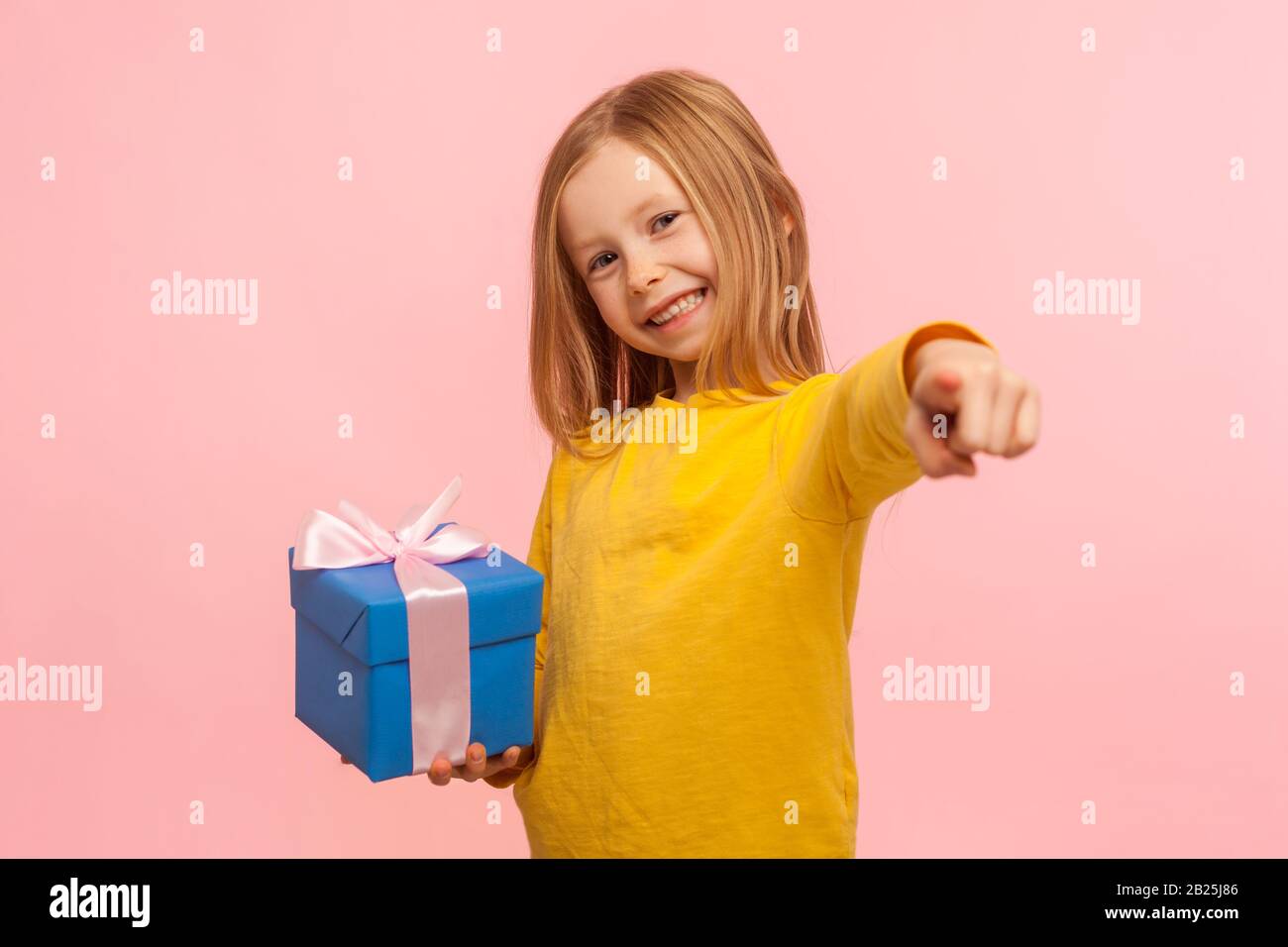 I have present for you! Portrait of kind generous little girl standing ...