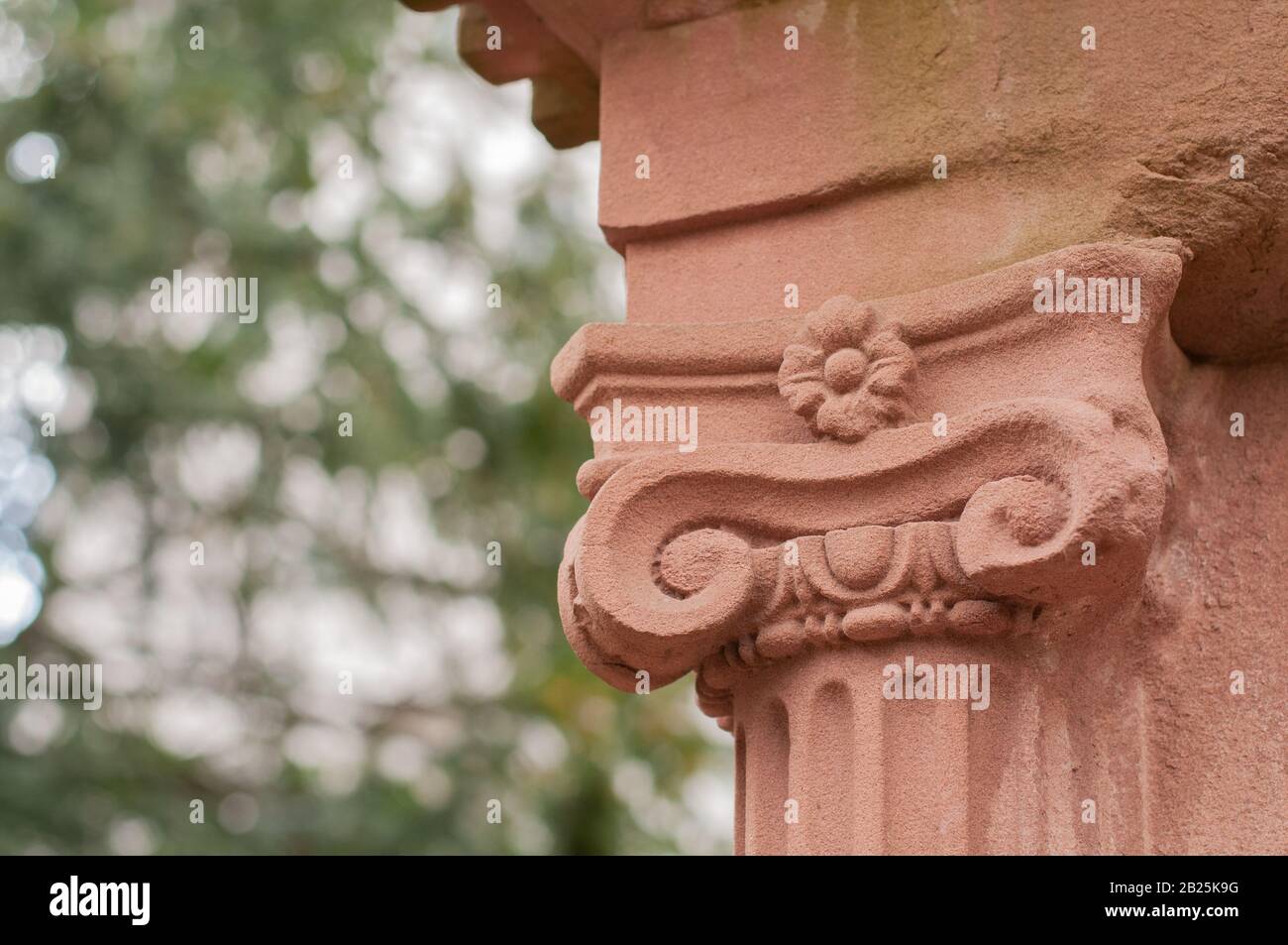 ionic capital of a half column carved in pink sandstone at an old ...
