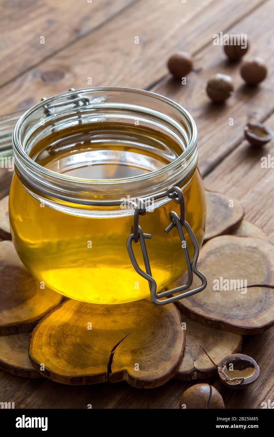 Indian ghee in liquid form on a wooden table with macadamia nuts Stock ...