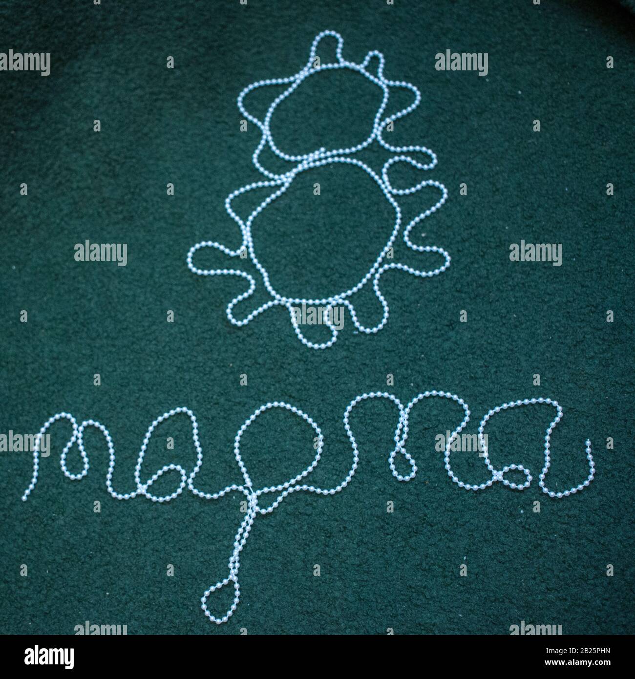 8 March symbol. Figure of eight made of white beads against green ...