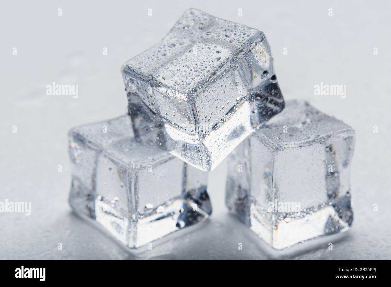 Ice cubes in the form of a pyramid with water drops close - up in macro ...