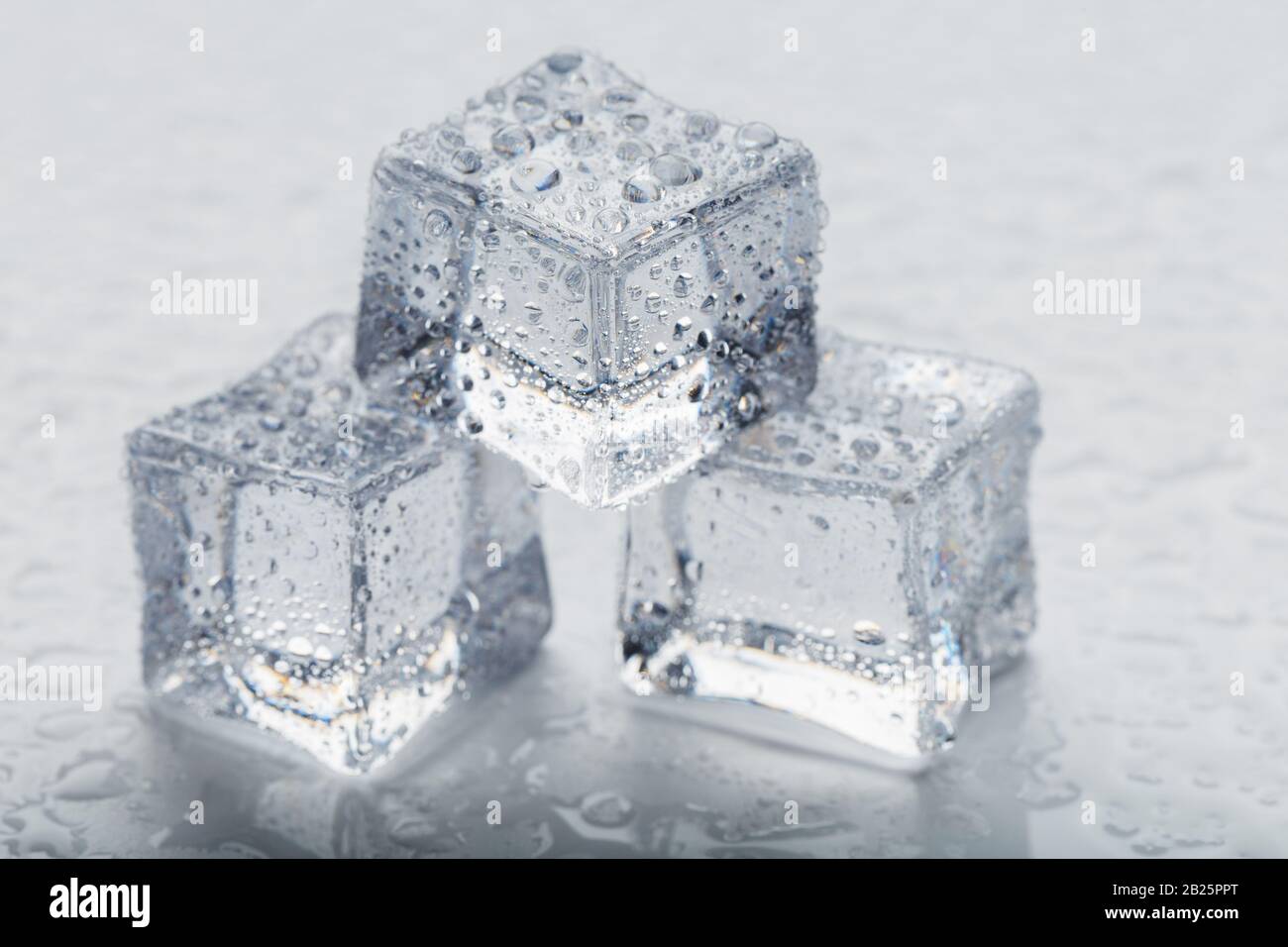 Ice cubes in the form of a pyramid with water drops close - up in macro ...