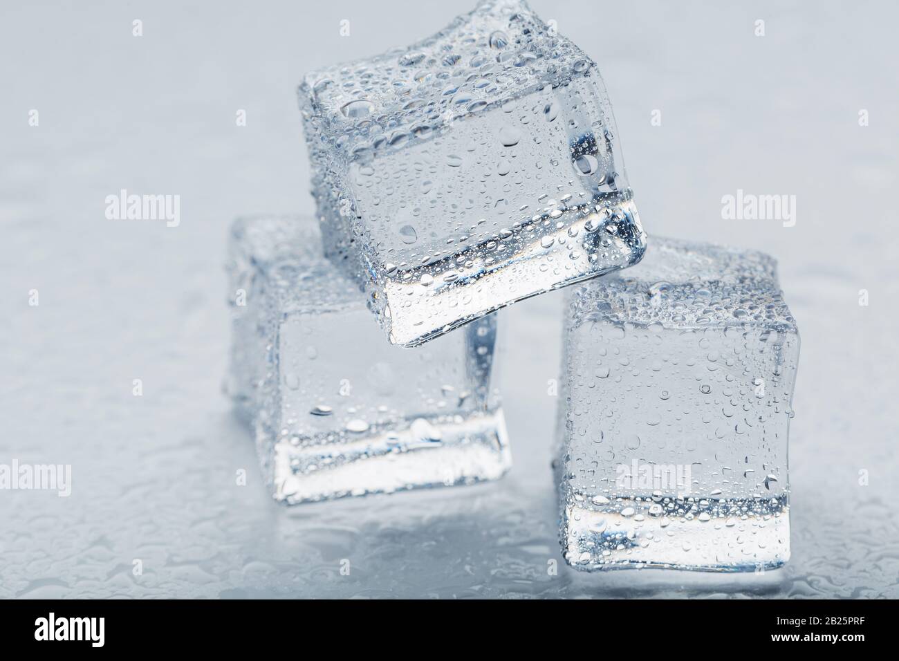 Ice cubes in the form of a pyramid with water drops close - up in macro ...